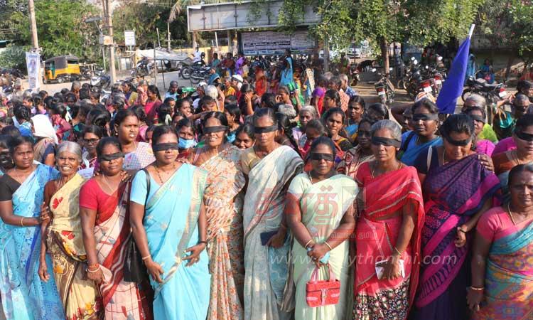 Anganwadi workers demonstrate by tying black cloth over their eyes ...