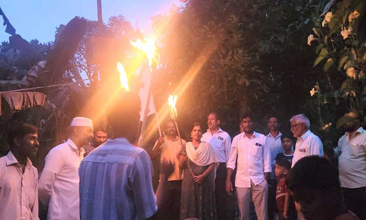 People carry torches and protest for the installation of street lights ...